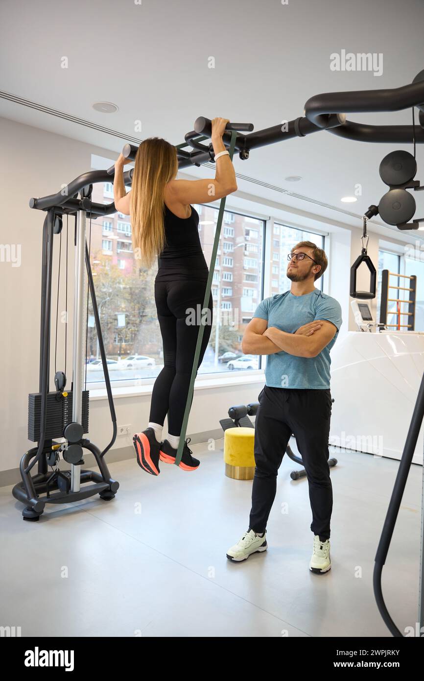 Lady in the gym doing pull-ups on the horizontal bar Stock Photo - Alamy
