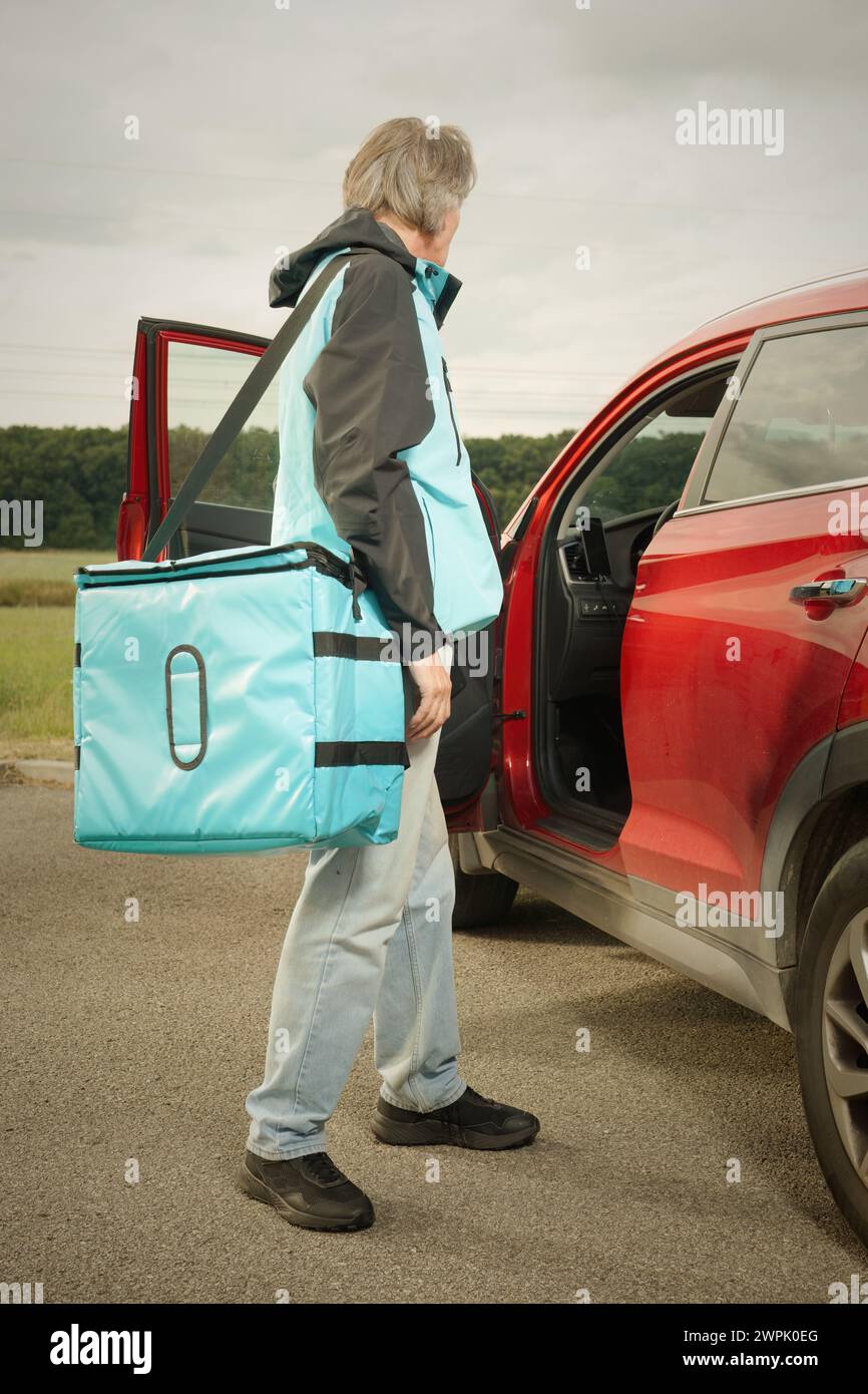 Older man in car delivering food order to it's customer Stock Photo - Alamy