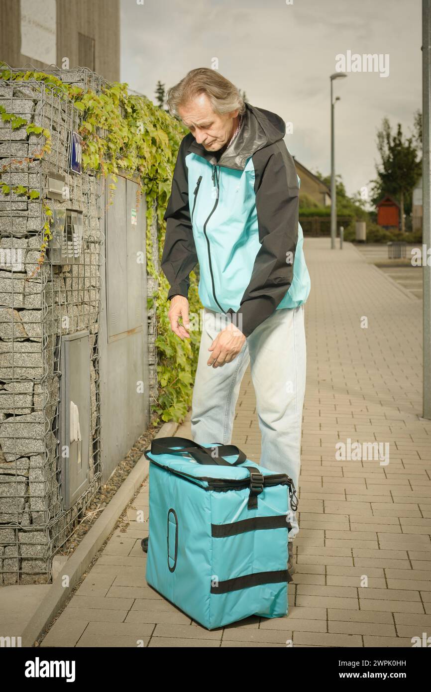 Older man delivering food order to it's customer looking for address ...