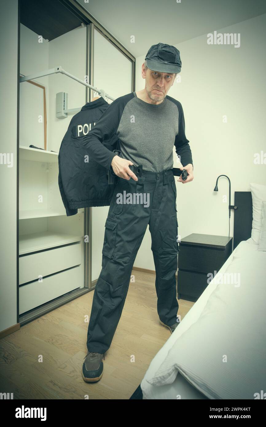 Older slim city police officer dressing up in bedroom for service Stock ...
