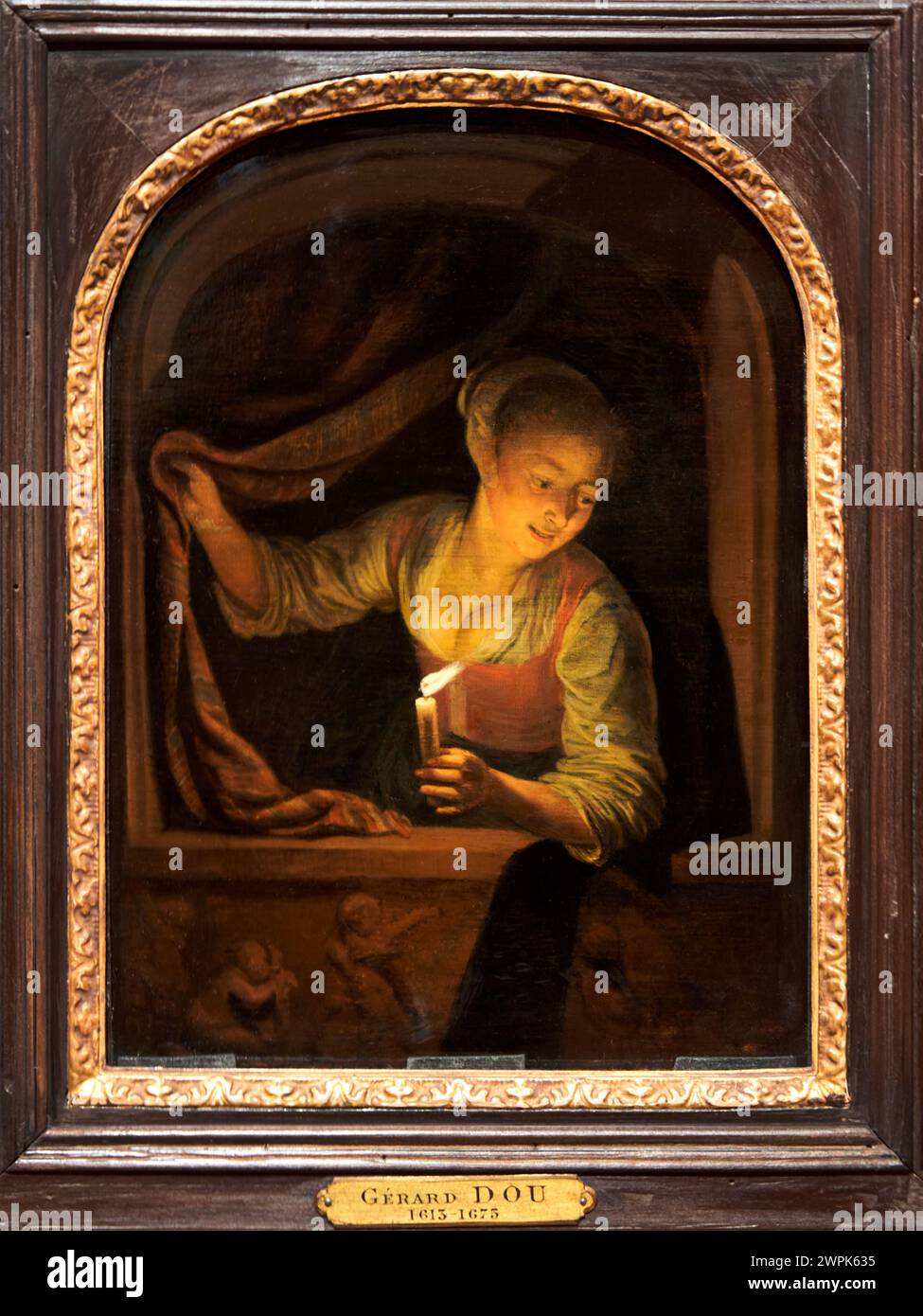 Young woman with a lighted candle at a window hi-res stock photography ...