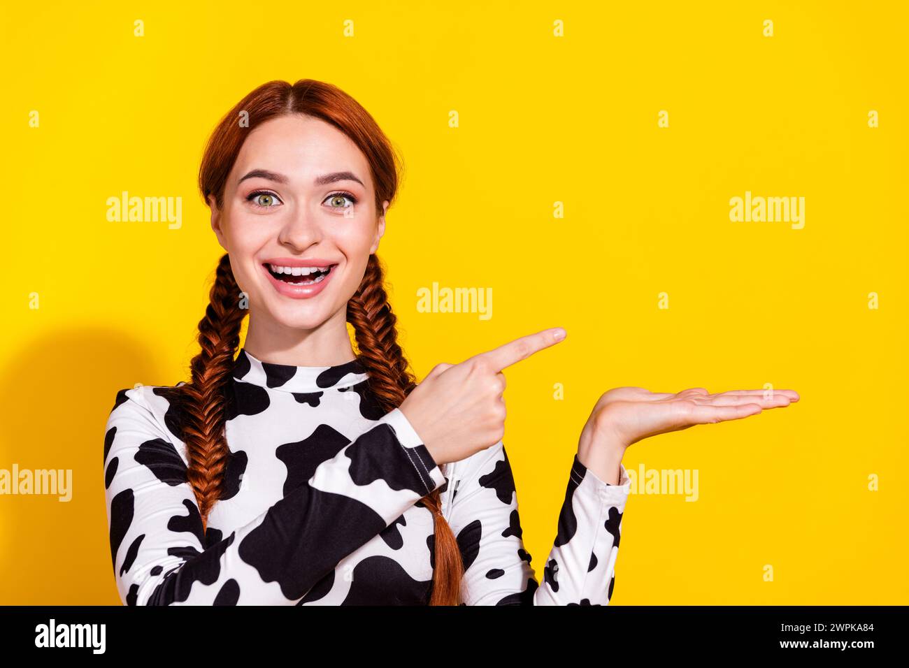 Photo of excited funky woman wear cow skin top holding arm showing ...