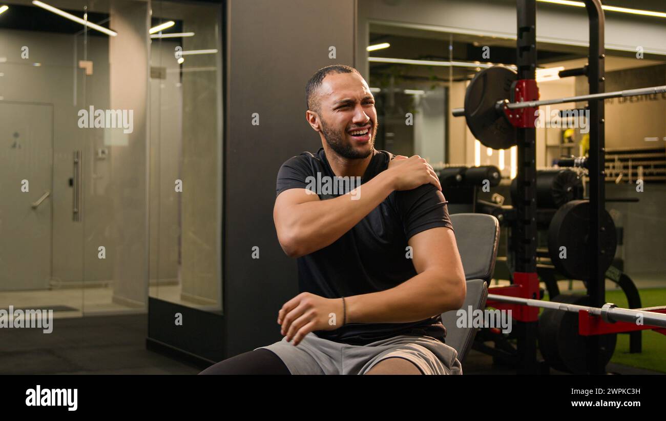 Latino ethnic multiracial American strong man sitting in gym press lift ...