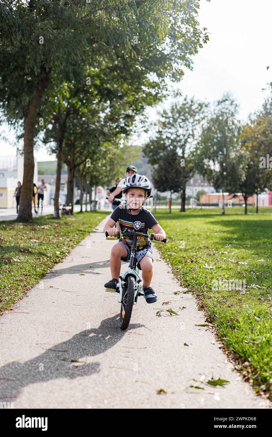A young boy riding on his bicycle in summer with a helmet on Stock ...
