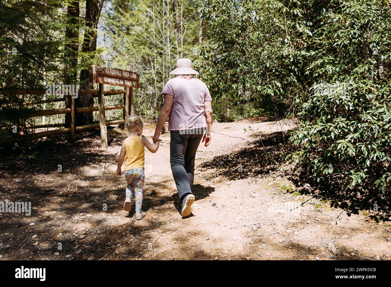 Grandma and granddaughter holding hands on hiking trail during s Stock ...