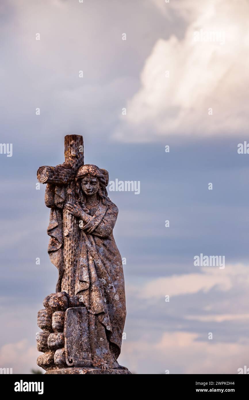 Sculpture of a woman embracing the cross Stock Photo - Alamy