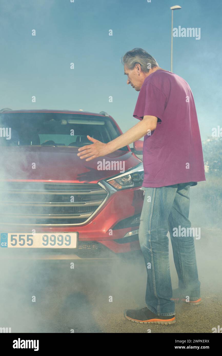 Pensioner checking state of his car with smoking engine Stock Photo - Alamy