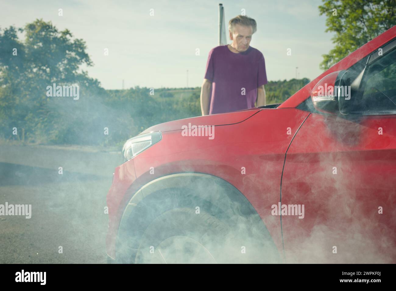Pensioner checking state of his car with smoking engine Stock Photo - Alamy