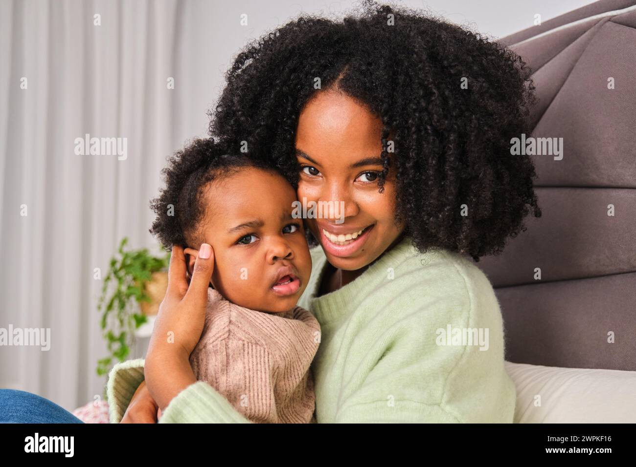 Portrait of Cuban mother and daughter looking at camera at home Stock ...