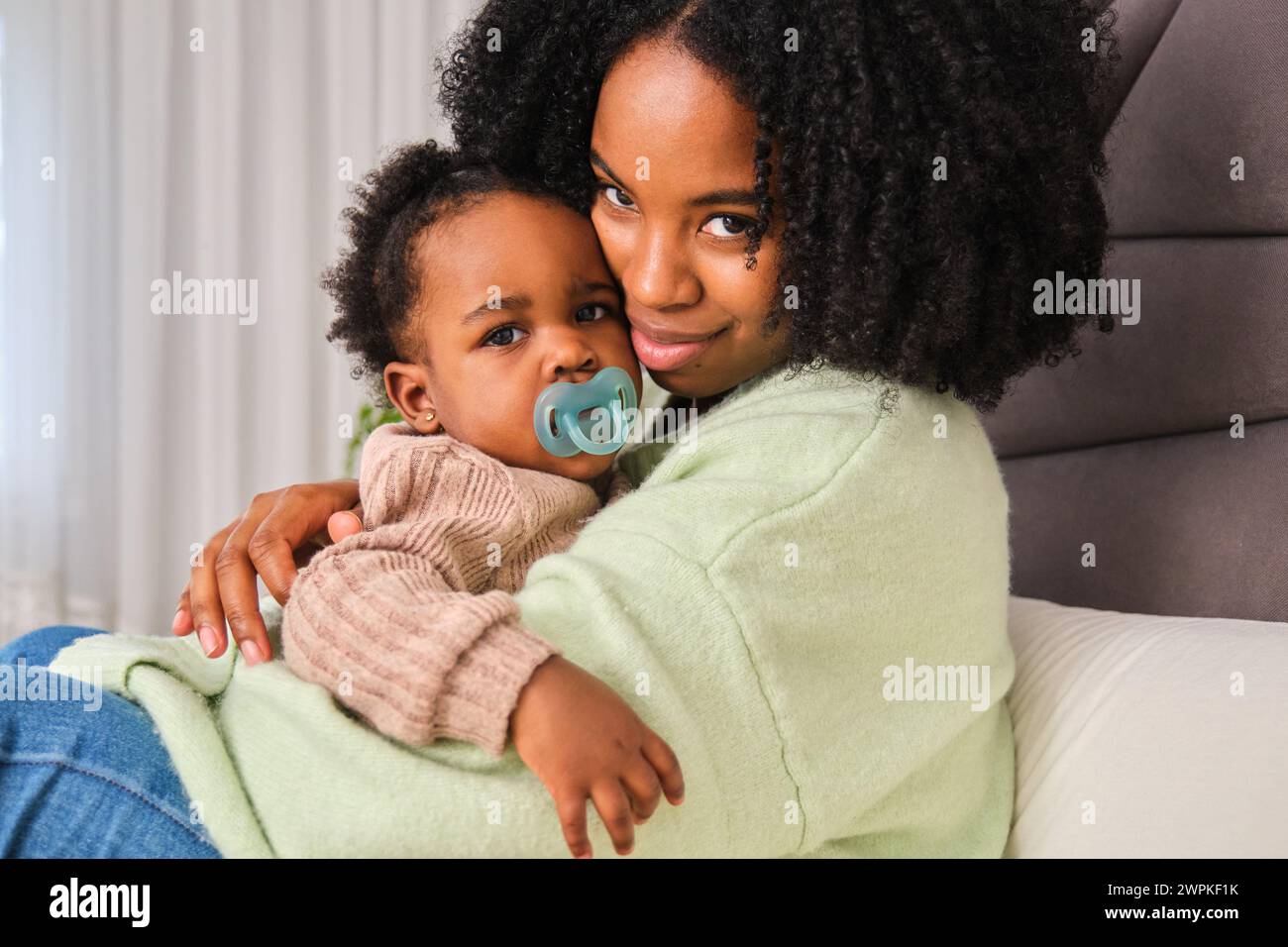 Portrait of Cuban mother and daughter looking at camera at home Stock ...