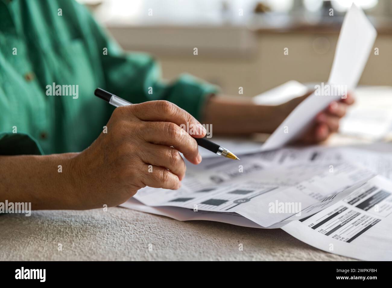 elderly woman hand with pen on paperwork with bills and receipts Stock ...
