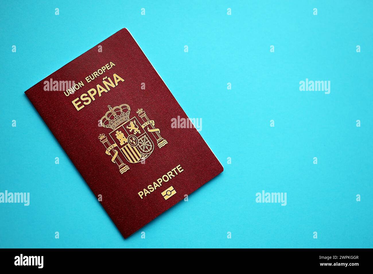 Red Spanish passport of European Union on blue background close up ...