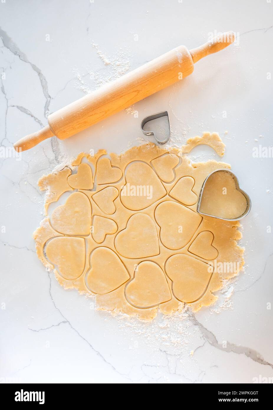 Top view of cookie dough cut into heart shapes on marble counter Stock ...
