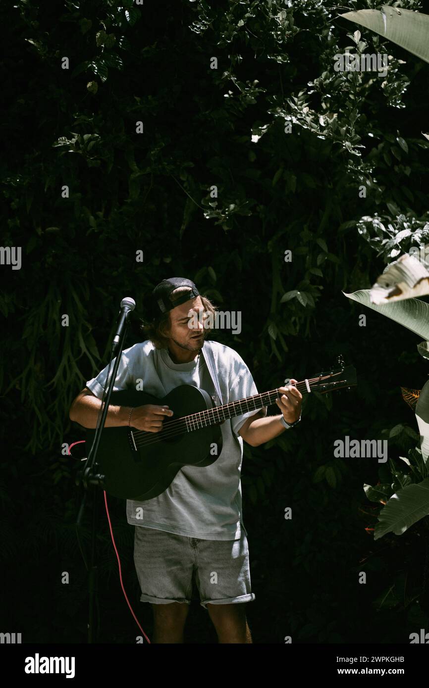 Young man singer, sings into a microphone and plays the guitar Stock ...