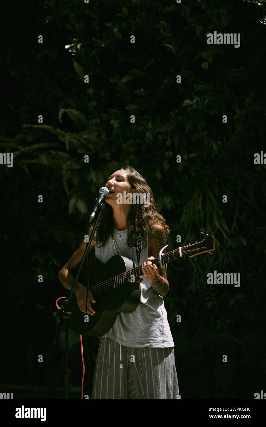 Young woman singer, sings into a microphone and plays the guitar Stock ...