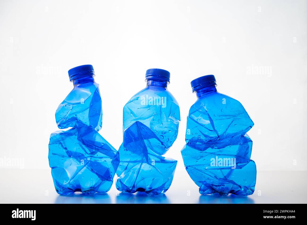 Plastic bottles, blue and transparent, crushed. Waste and plastic ...