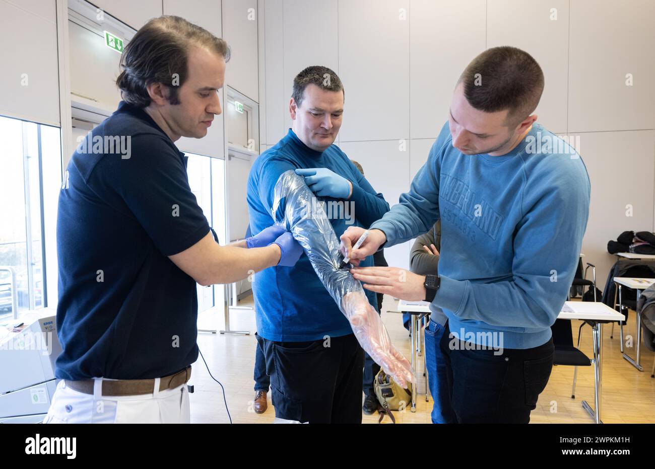 08 March 2024, Hesse, Frankfurt/Main: A trainer (l) uses a human hand ...