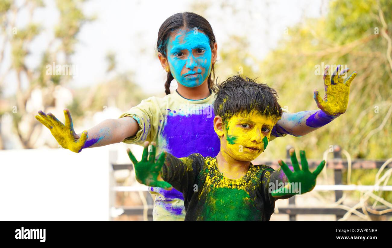Young cute cheerful little kids with applied holi colors powder showing ...