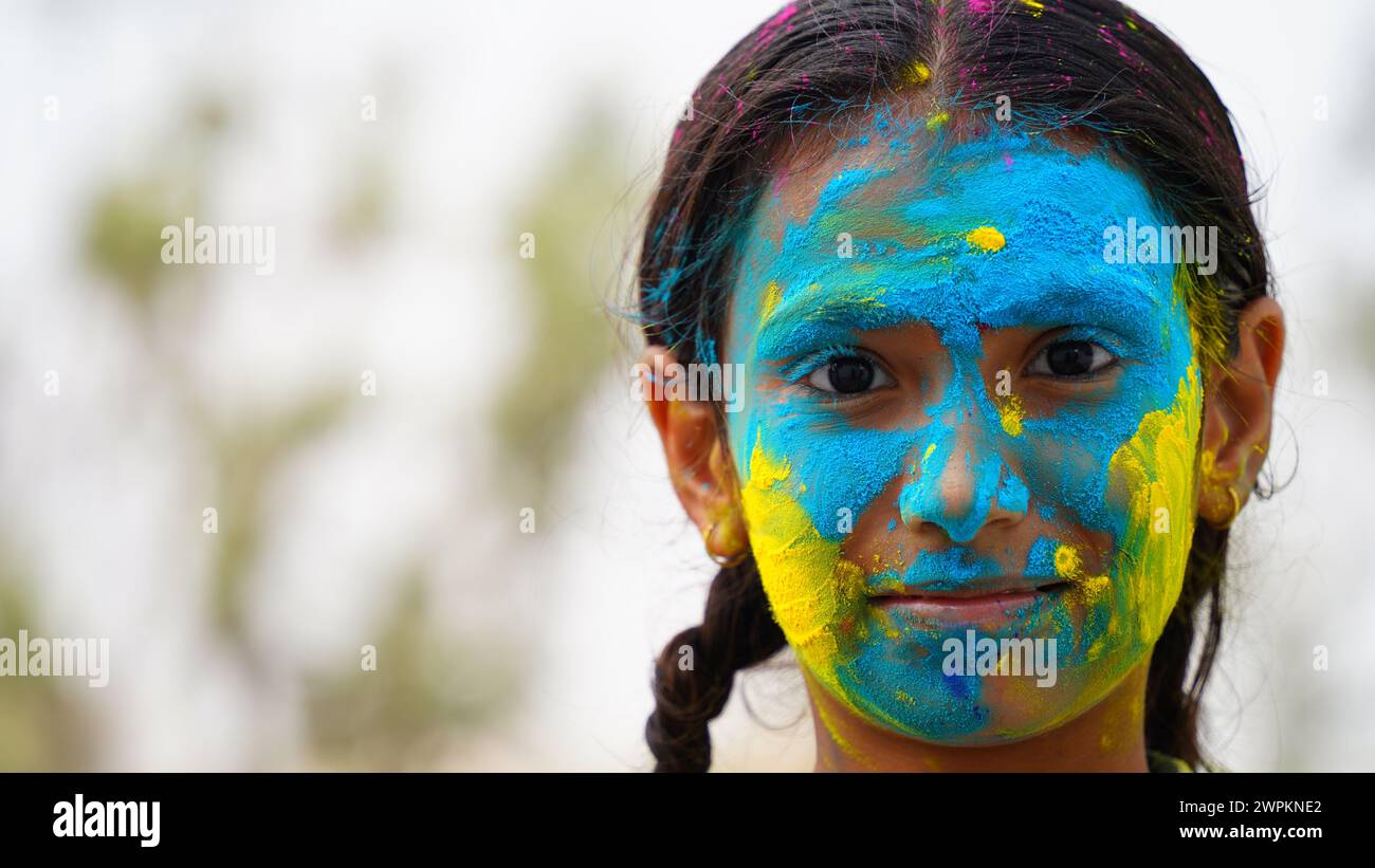Young cute cheerful little girl kid with applied holi colors powder ...