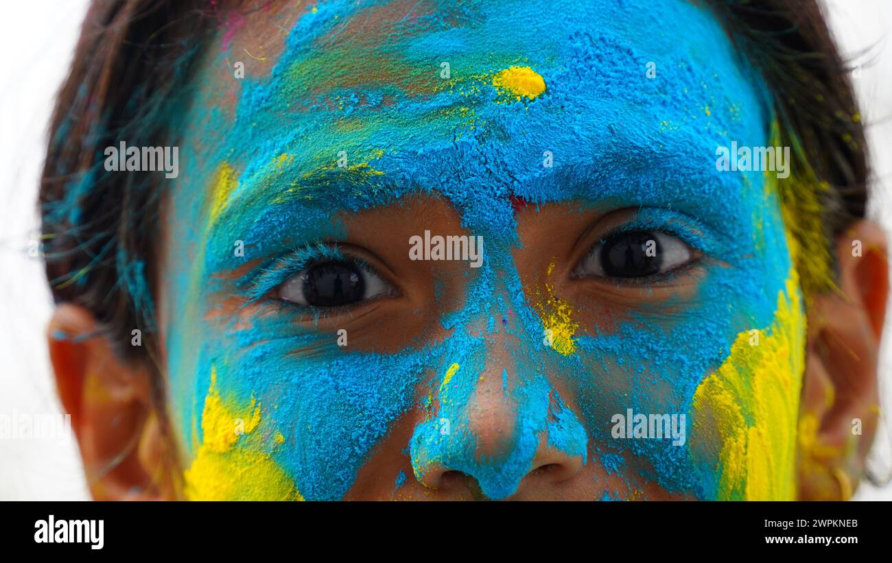 Kid blowing holi colour powder from hand during Holi festival ...