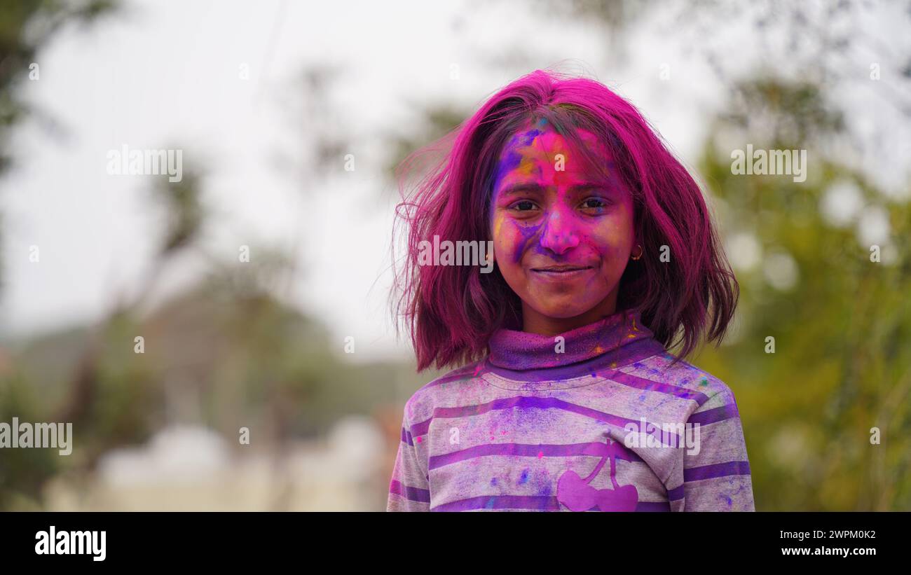 Kid blowing holi colour powder from hand during Holi festival ...