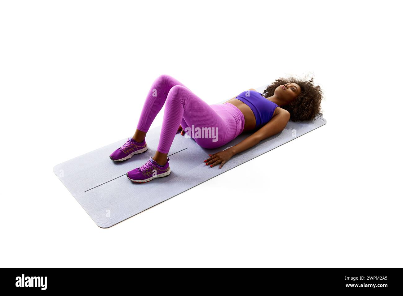 Angle view of young Africa-American woman lying on exercise mat and ...
