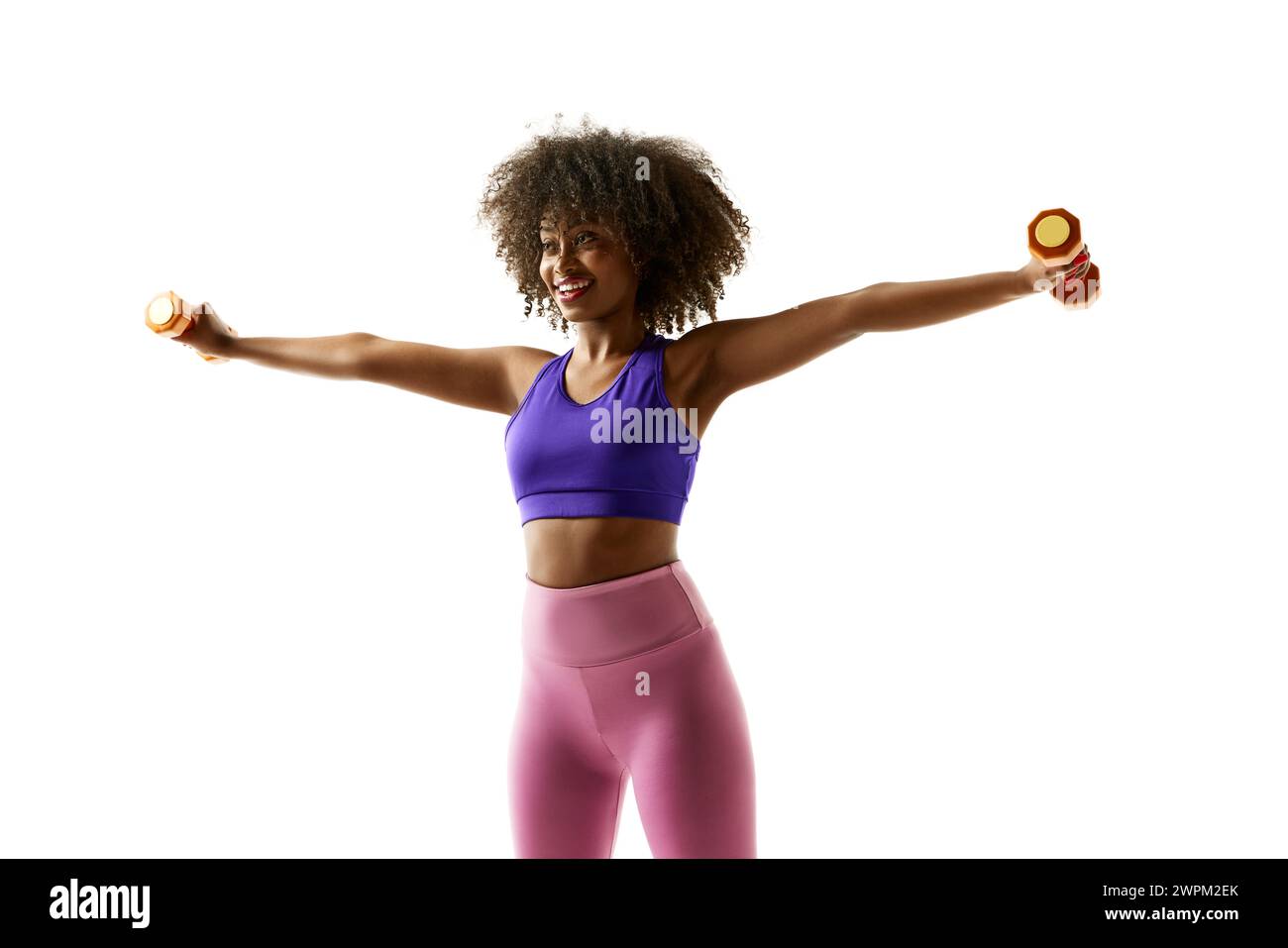 Athletic African-American woman with curly hair lifting weights ...