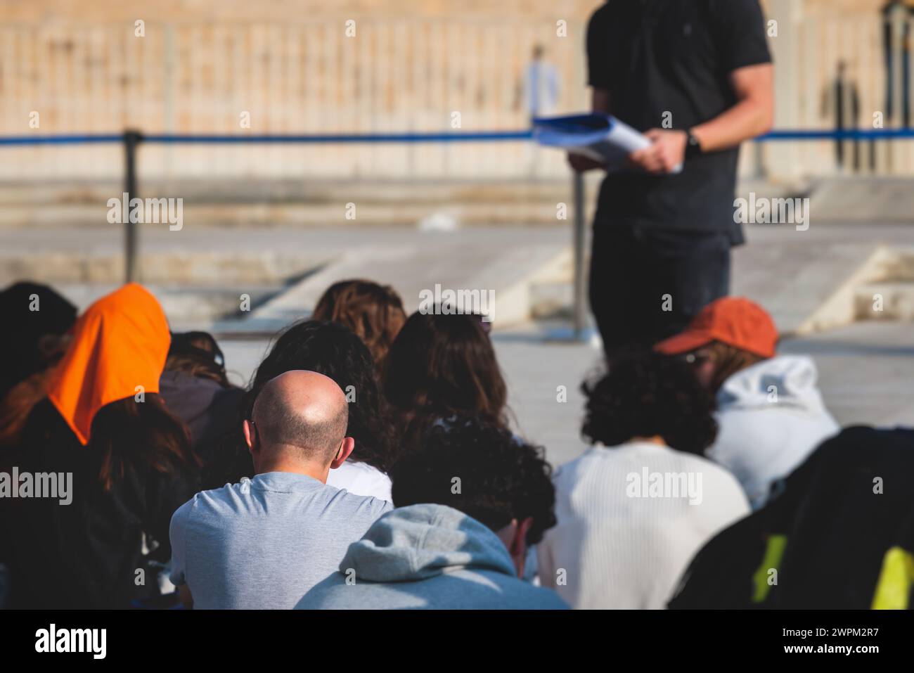Group of tourists sitting during outdoor excursion tour in the city ...