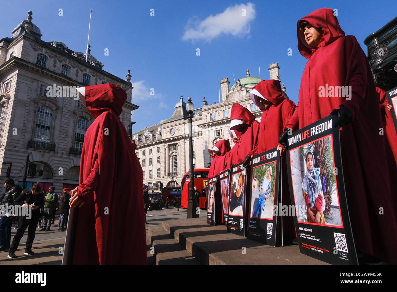 London, UK. 8th Mar 2024. Iranian women wearing the Handmaid's Tale red ...