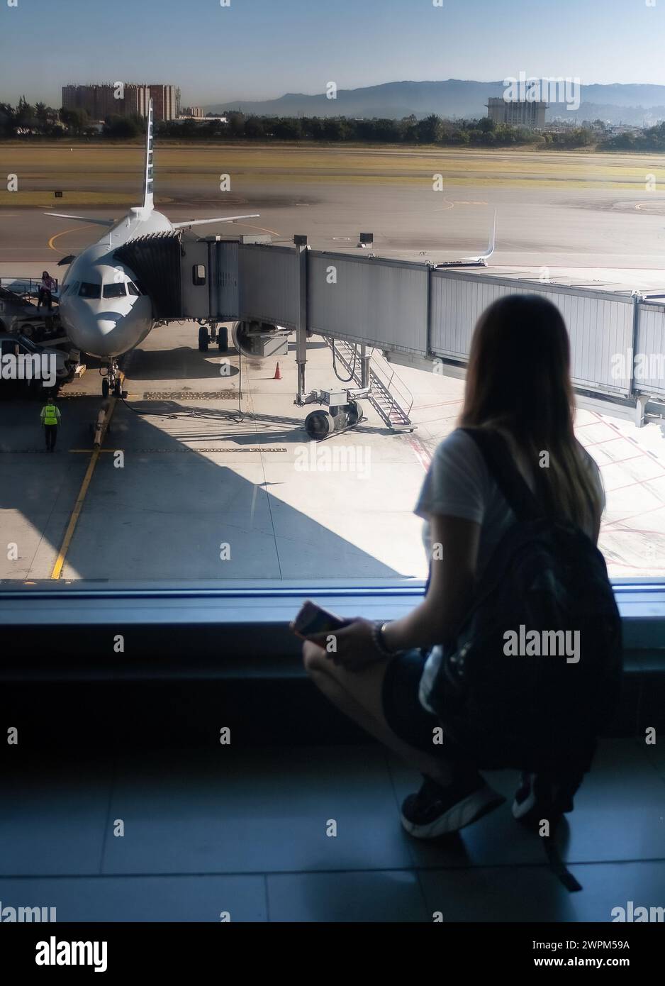 Woman looking through window of plane hi-res stock photography and ...