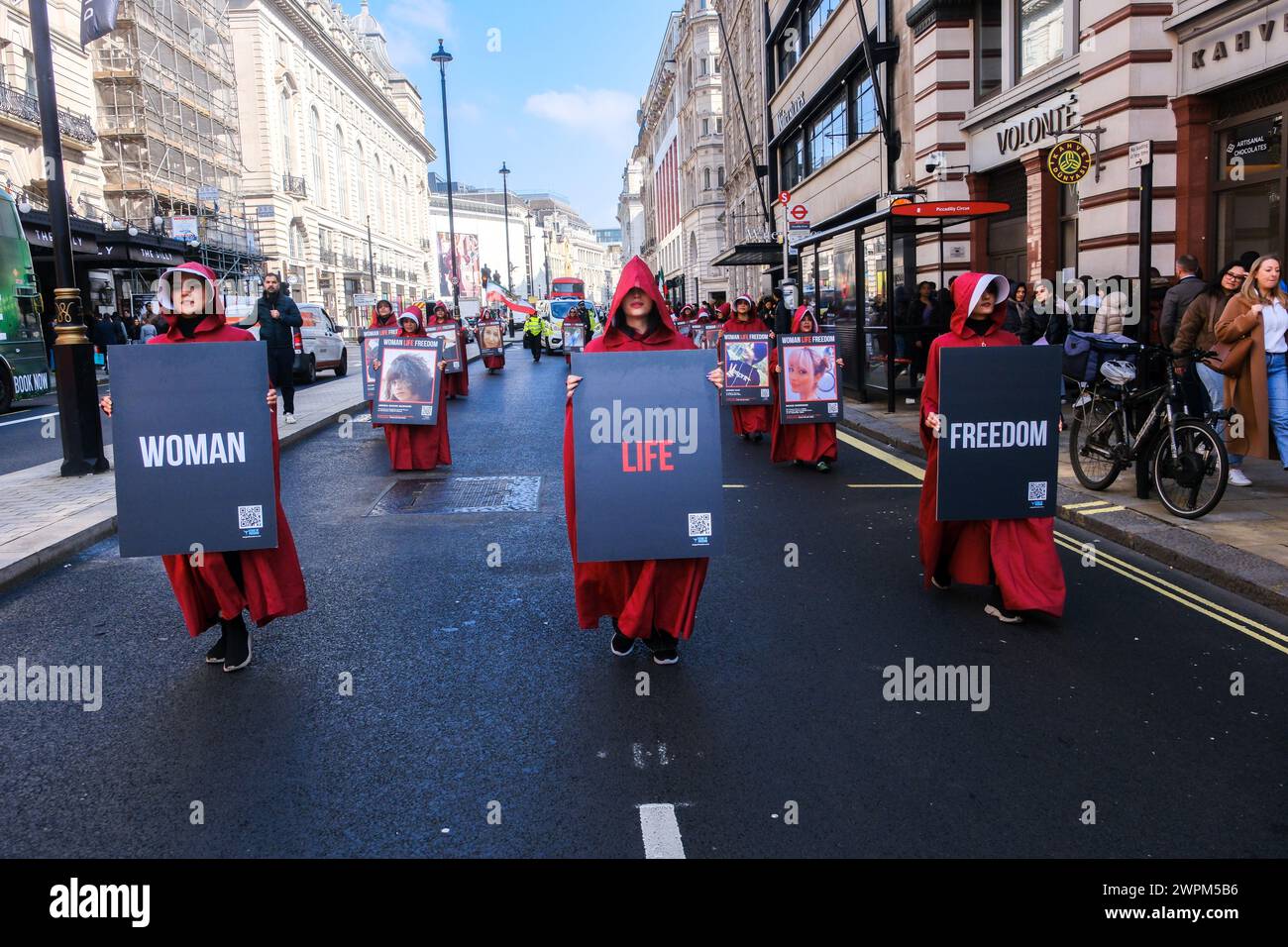 London, UK. 8th Mar 2024. Iranian women wearing the Handmaid's Tale red ...
