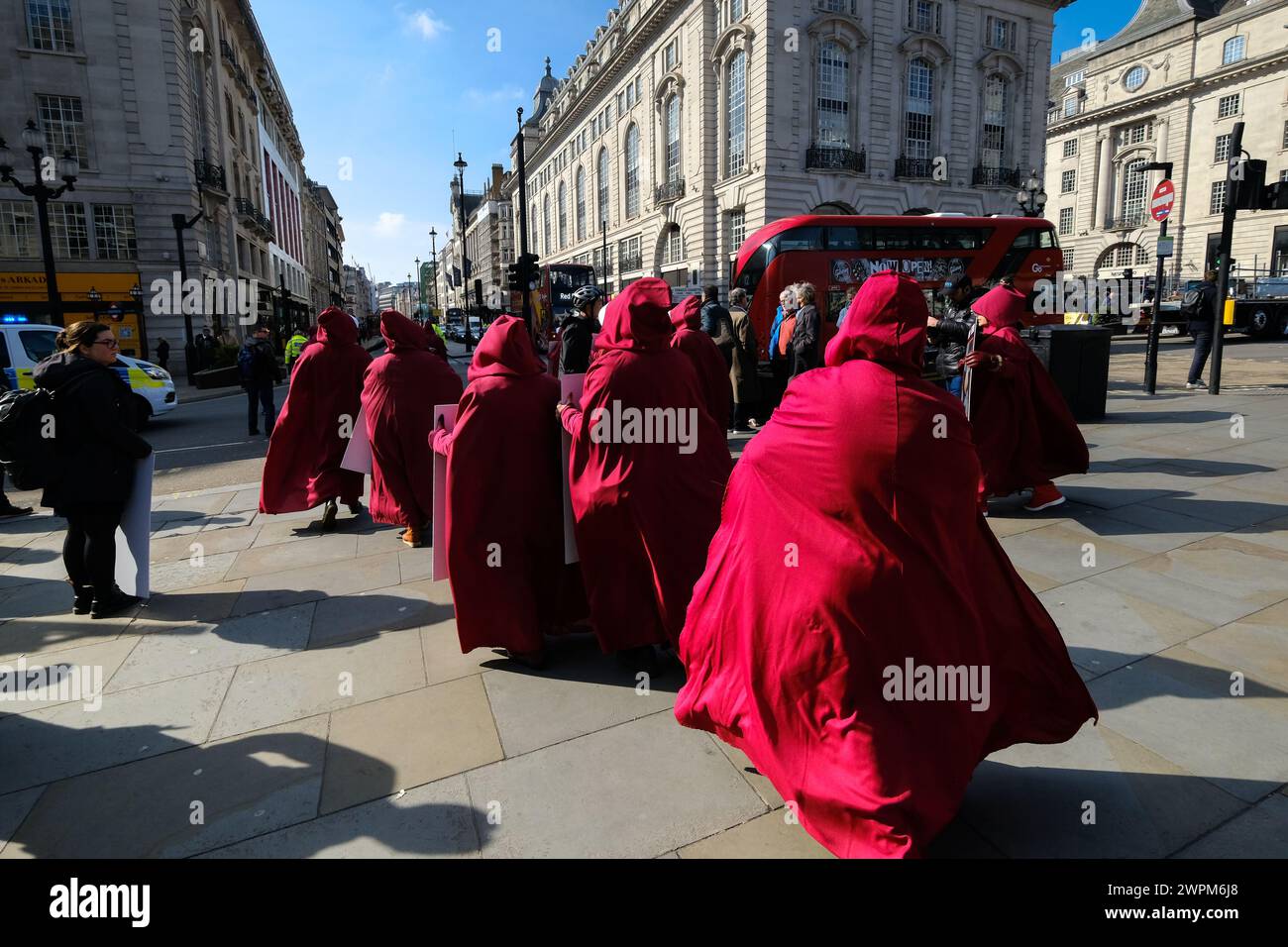 London, UK. 8th Mar 2024. Iranian women wearing the Handmaid's Tale red ...