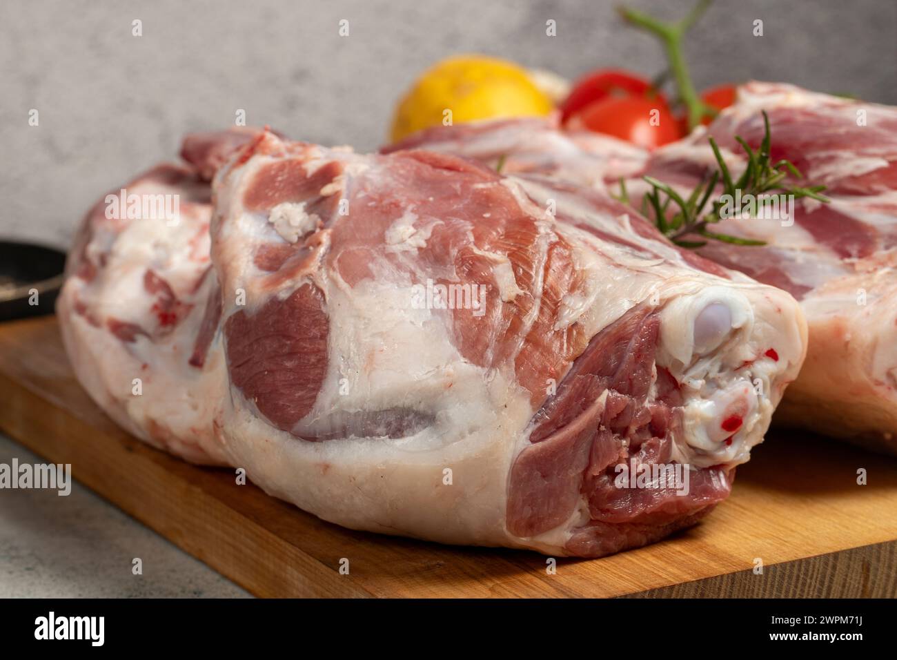 leg of lamb Butcher products. Raw lamb leg meat with bones on stone ...