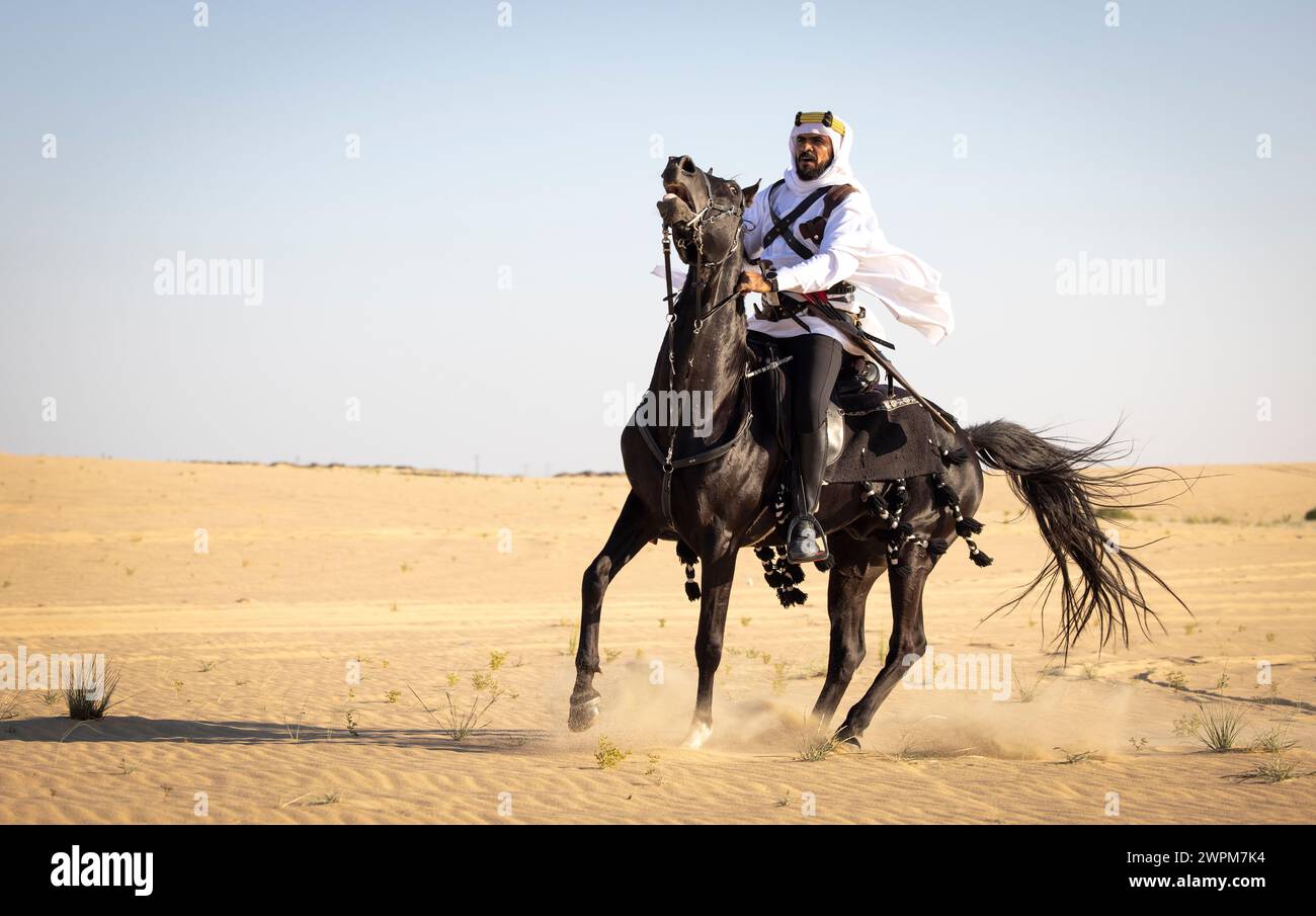 Saudi arabina man riding on his black stallion in a desert Stock Photo ...