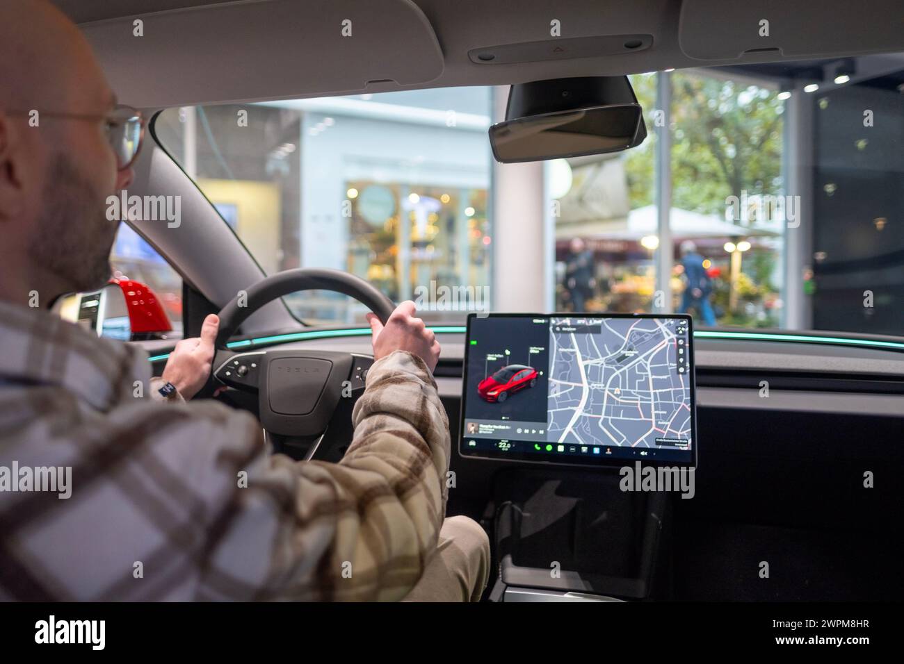 Tesla test drive, Young man, potential buyer, sits in car interior ...