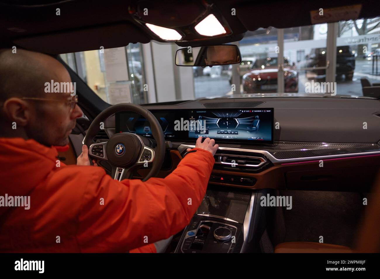 closeup male driver's hand manipulates on electronic display, steering ...