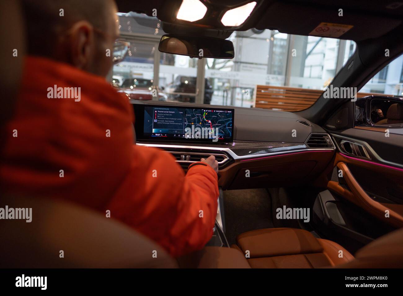 close-up man in car driving BMW i4 five-door electric liftback class D ...