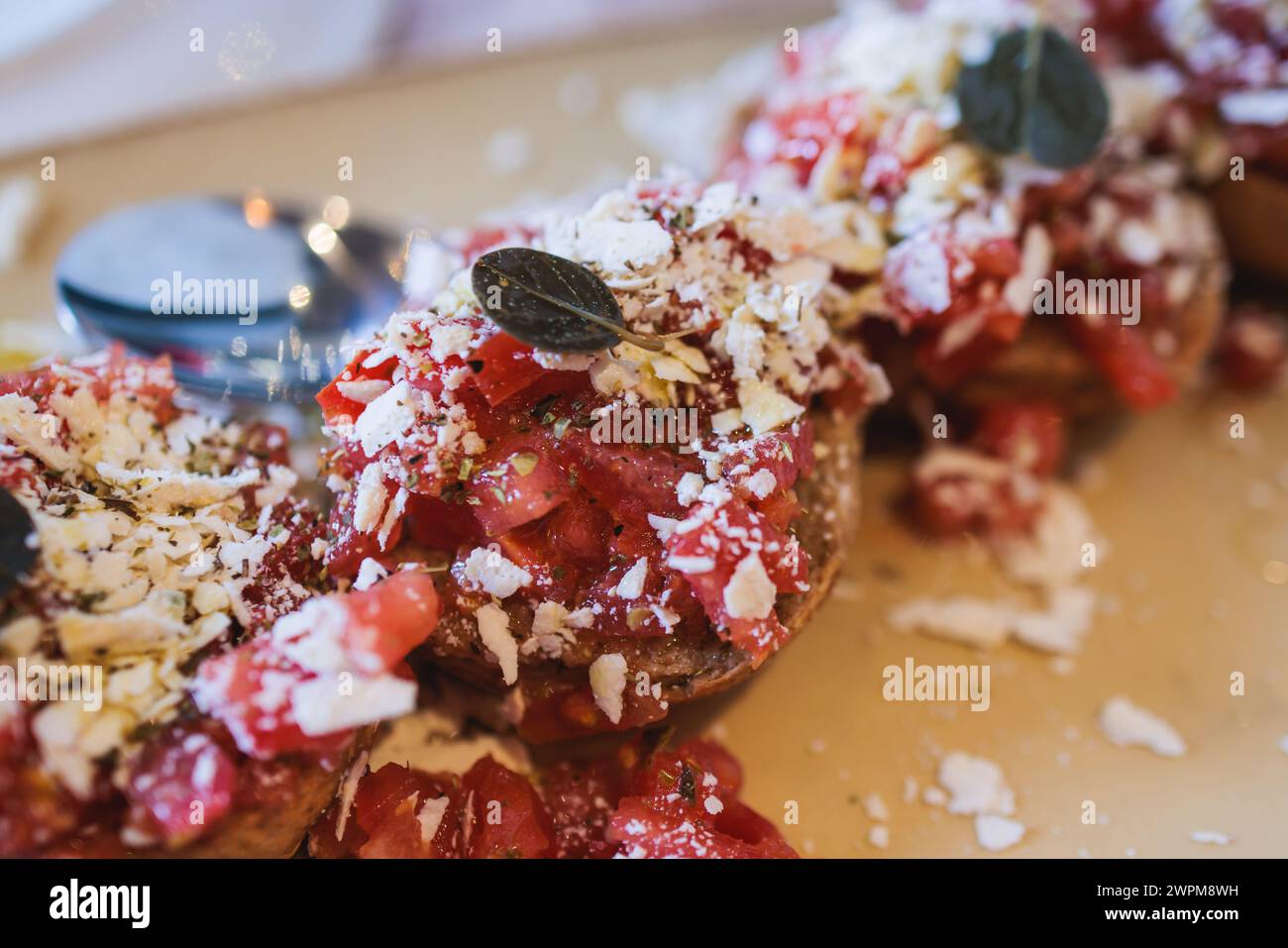 Cretan Ntakos on a plate in a greek cafe taverna, Dakos salad, barley ...