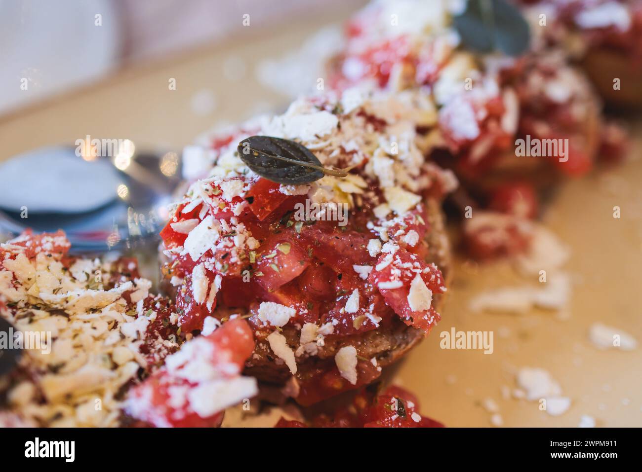 Cretan Ntakos on a plate in a greek cafe taverna, Dakos salad, barley ...