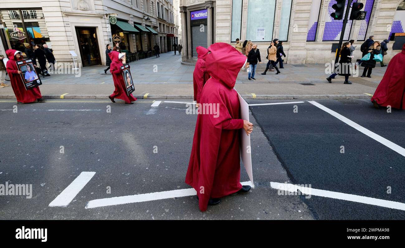 London, UK. 8th Mar 2024. Iranian women wearing the Handmaid's Tale red ...