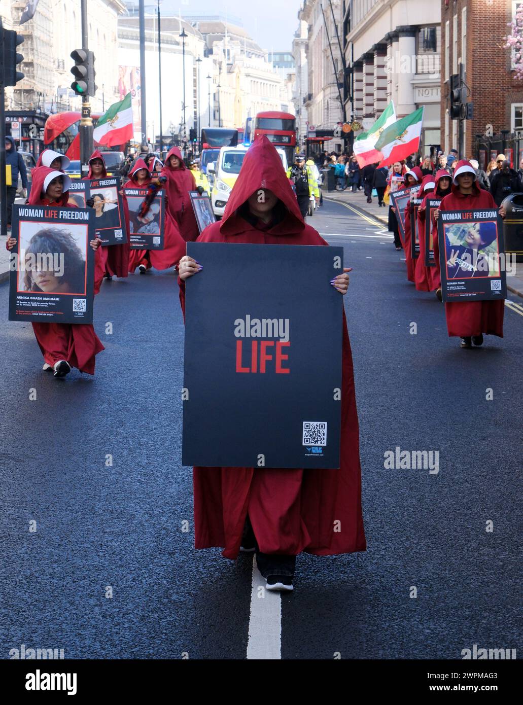 London, UK. 8th Mar 2024. Iranian women wearing the Handmaid's Tale red ...