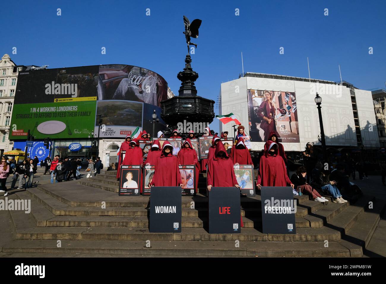 London, UK. 8th Mar 2024. Iranian women wearing the Handmaid's Tale red ...