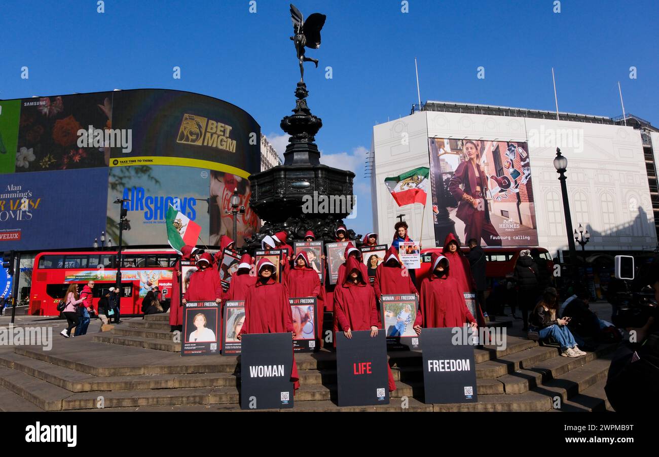 London, UK. 8th Mar 2024. Iranian women wearing the Handmaid's Tale red ...