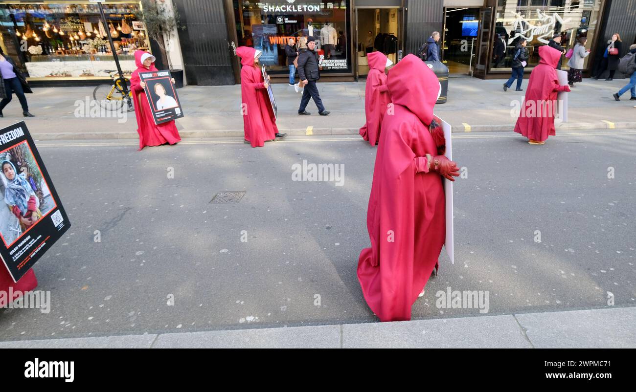 London, UK. 8th Mar 2024. Iranian women wearing the Handmaid's Tale red ...
