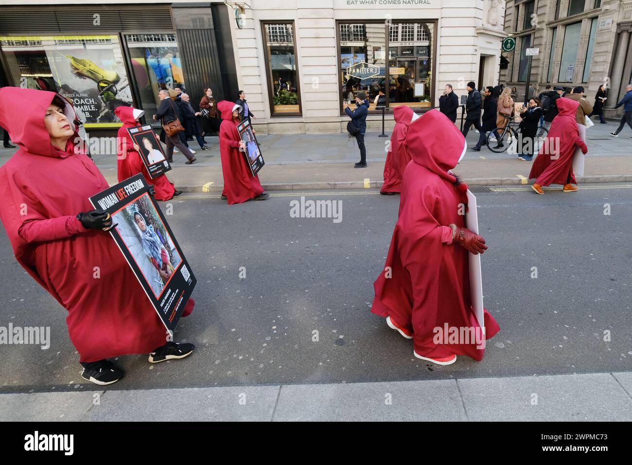 London, UK. 8th Mar 2024. Iranian women wearing the Handmaid's Tale red ...