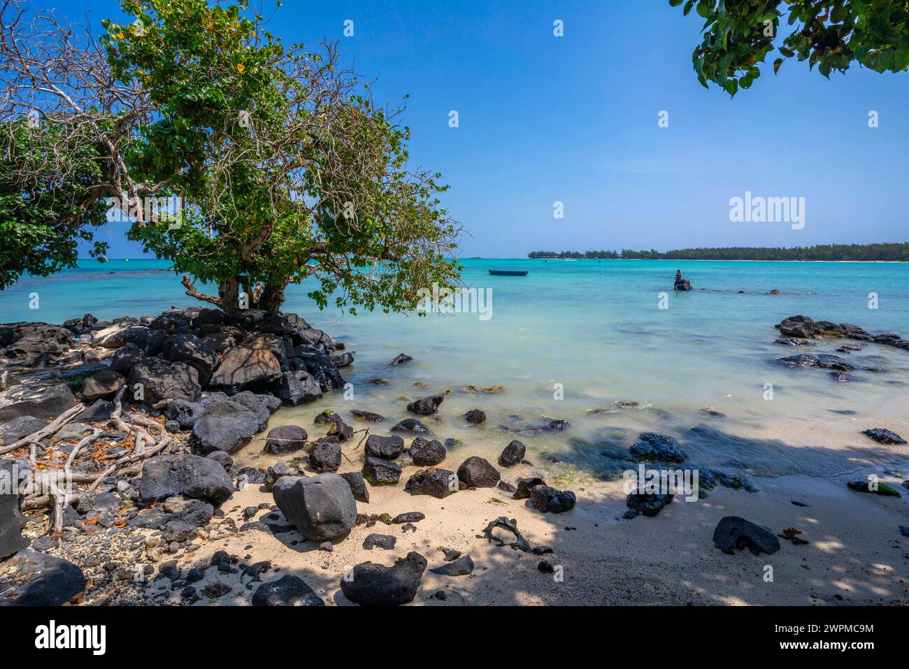 View of man fishing from Mont Choisy Beach and turquoise Indian Ocean ...