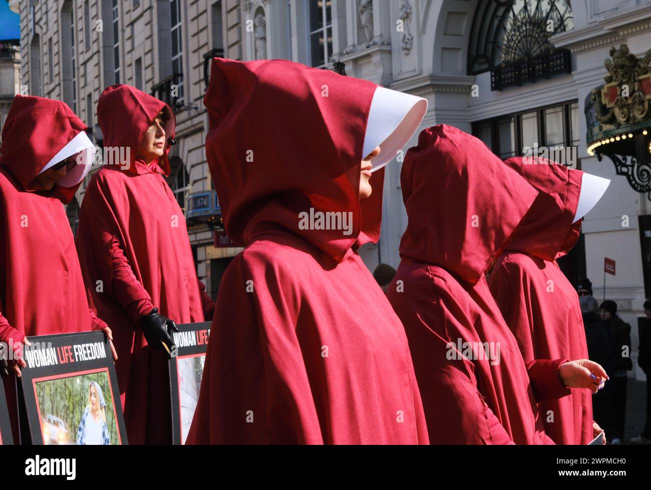 London, UK. 8th Mar 2024. Iranian women wearing the Handmaid's Tale red ...