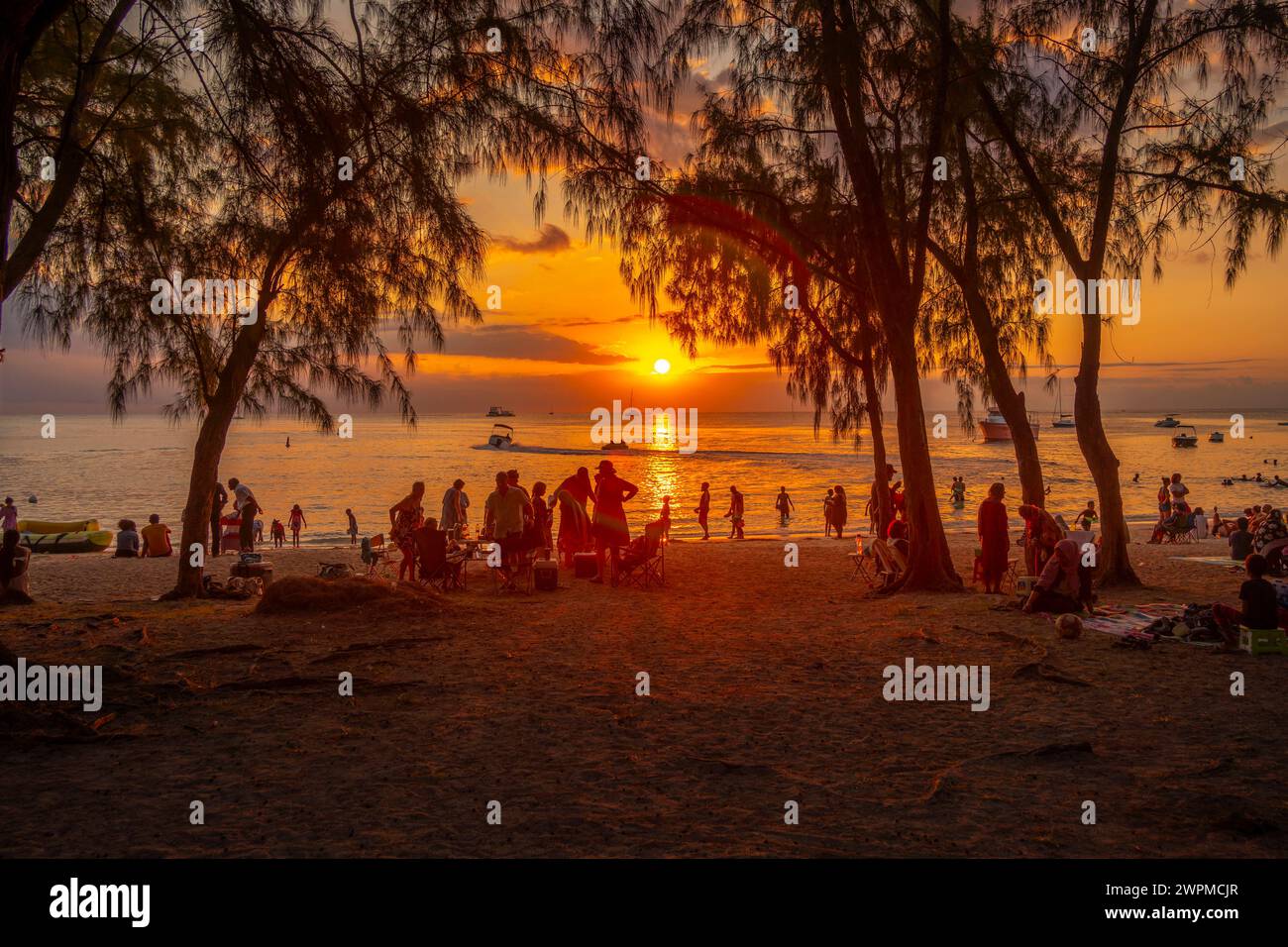 View of people on Mon Choisy Public Beach at sunset, Mauritius, Indian ...