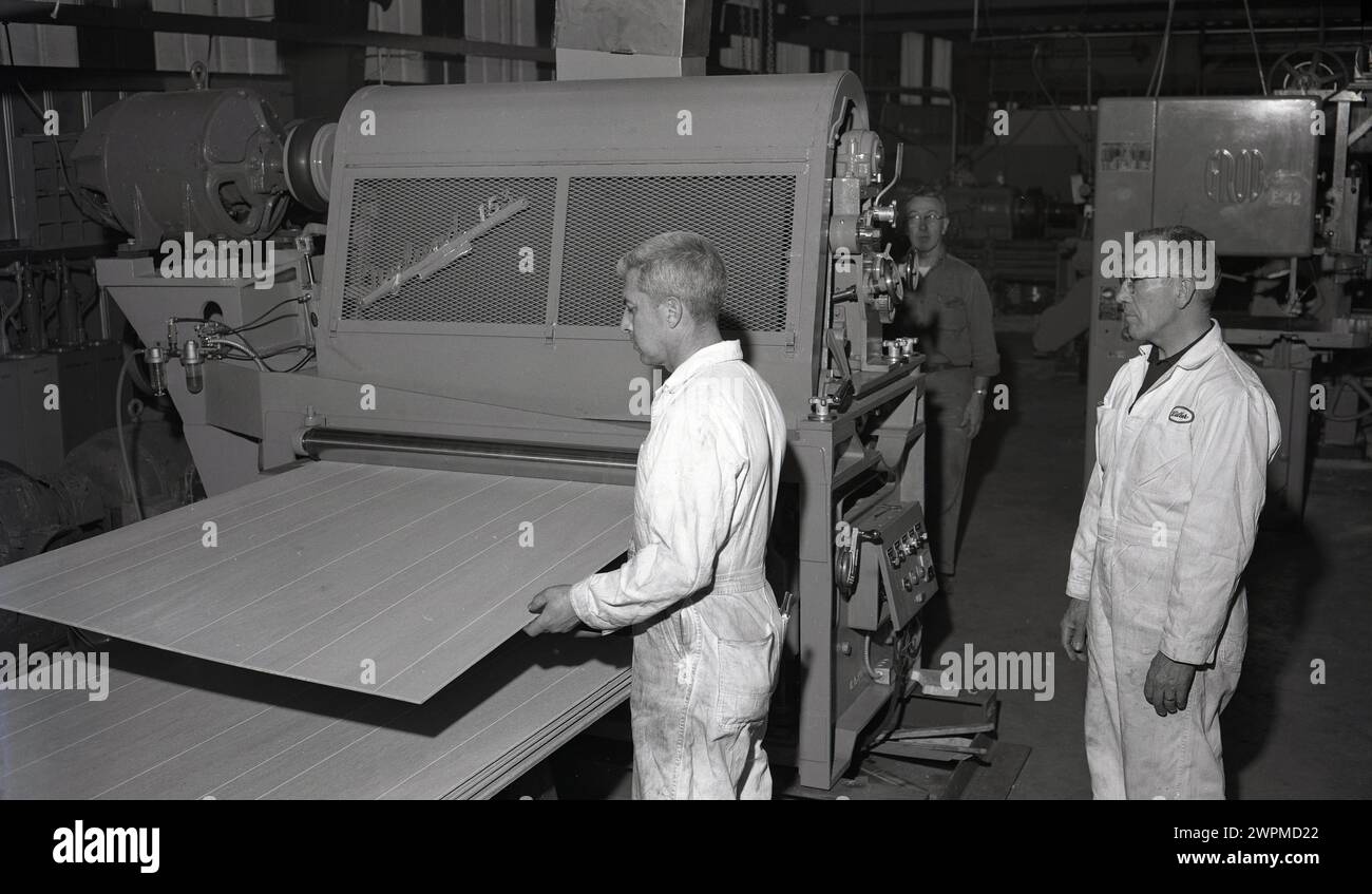 1950s, historical, two male workers in overalls on a production floor ...
