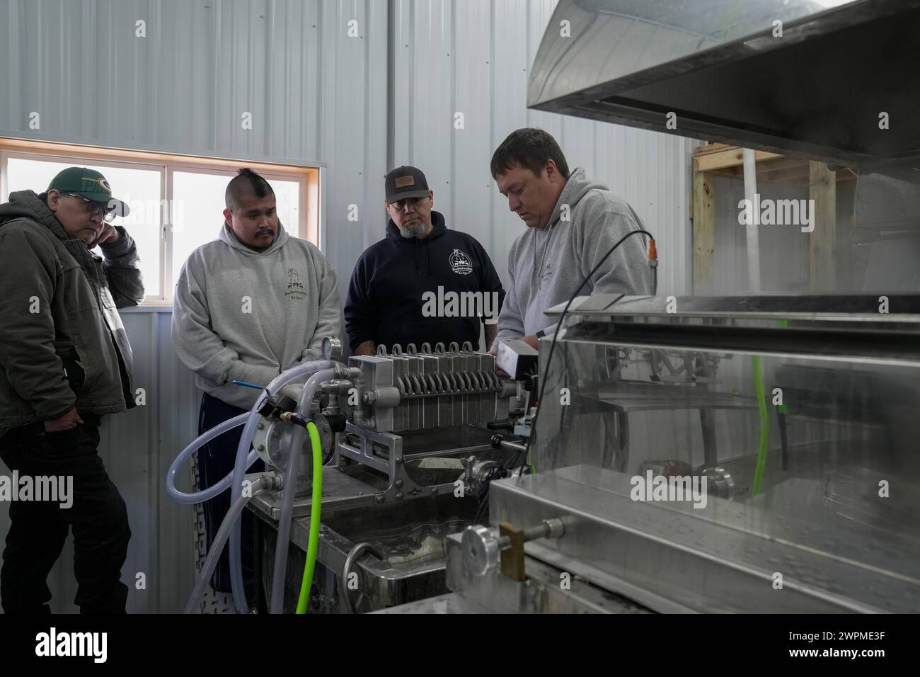 Joe Shepard, right, loads plates into a filter press as he shows how to ...